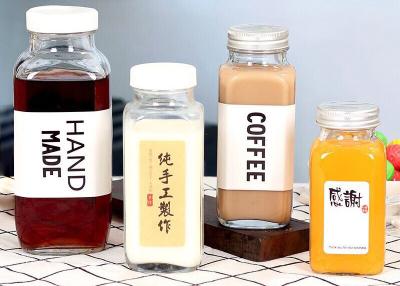 中国 正方形の明確なガラス飲料はプラスチックねじふたが付いている500ml注文のラベルをびん詰めにする 販売のため