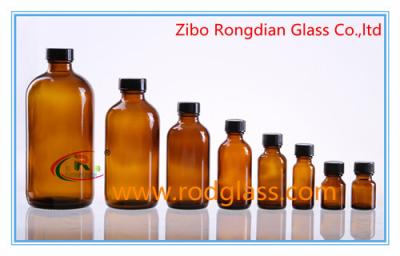 China Amber glass bottle Boston Round with black phenolic cap for sale