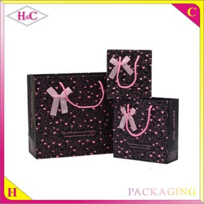 China Luxury fashion hand length handle paperboard gift bag with ribbon for sale