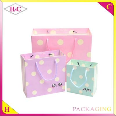 China Cartoon hand length handle paperboard packaging bag for sale