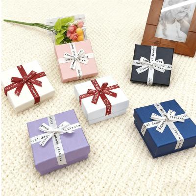 China Caja cuadrada cielo y tierra de embalaje de joyería personalizada con lazo de cinta en inglés, cubierta de cartón elegante para aretes y anillos en venta