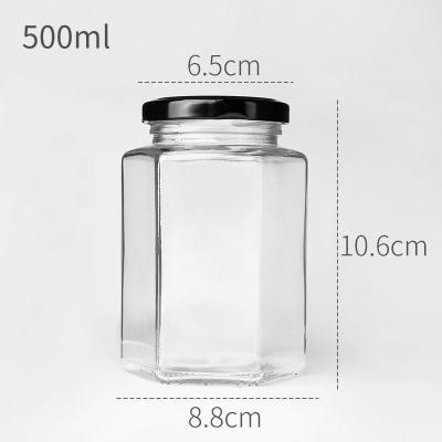 Cina Vaso esagonale in vetro a colori personalizzati per miele di crema 45ml 180ml 500ml 700ml in vendita