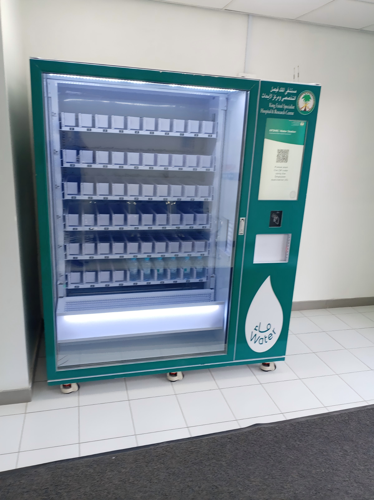 Large capacity elevator drink vending machine dispensing bottled water smoothly in a commercial Saudi Arabia venue