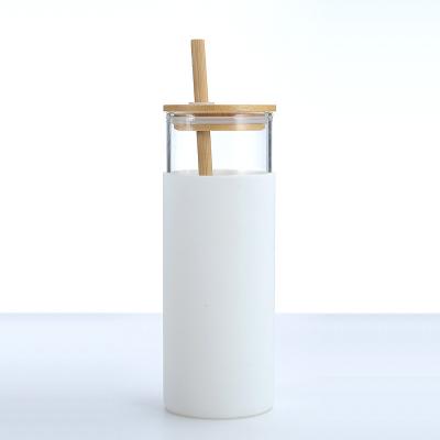 China Voedingsmiddelenwit 20 oz glazen fles met deksel siliconen beschermende mouw bamboe deksel glazen waterfles voor zowel warme als koude dranken Te koop