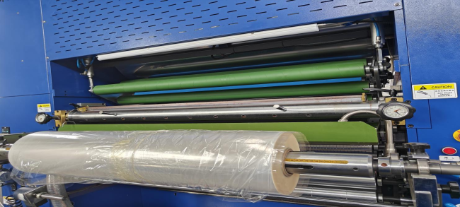 Film lamination machine in operation showing workflow process