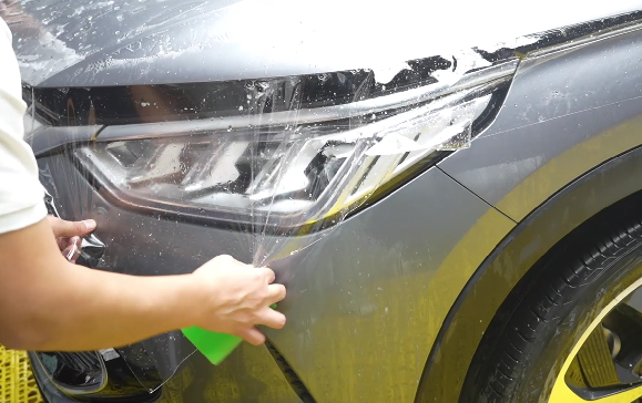 Professional applying GETSUN Matte Paint Protection Film to vehicle