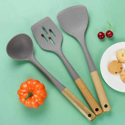 Cina Cucina in silicone Set in tre pezzi Scala resistente al calore Cucchiaio antiaderente Maniglia di legno in vendita