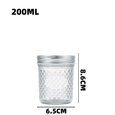 China Embossed Clear Glass Storage Jar With Screw Cap For Coffee Bean Peanut Oatmeal for sale