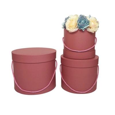 中国 さまざまな色のカスタム段ボールギフトラウンドシリンダーブーケ花箱パッケージング付きハンドル 販売のため