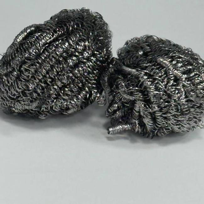 Stainless steel wire cleaning ball in use on cookware