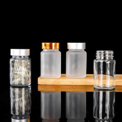 China 60ml 100ml 120ml clear frosted empty wide mouth pill capsules tablets powder medicine glass bottle container with sliver for sale