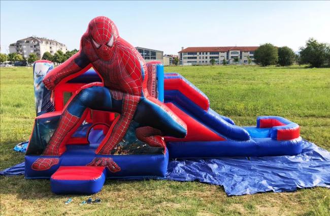 Children playing on Spiderman bounce house with slide