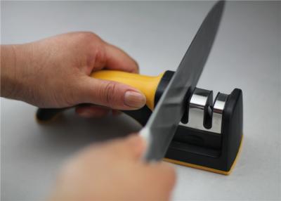 Cina La macchina per affilare i coltelli domestica tenuta in mano, funziona il coltello da cucina tagliente che affila gli strumenti in vendita