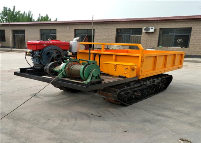 Compact hydraulic mini dumper with crawler tracks operating in rough terrain