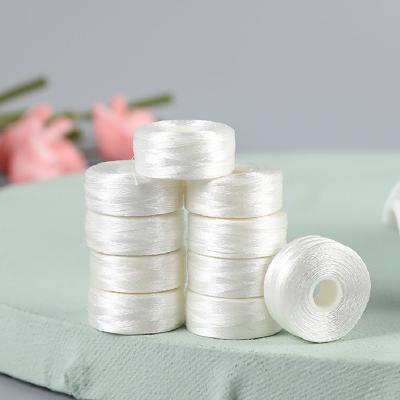 Cina 2 cm di diametro ricamo filo di fondo bianco senza confine L-tipo 75D/2 Shuttle Core cucitura prefondato bobbin 6 in vendita