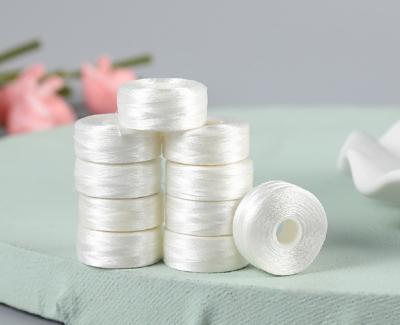 Cina 2 cm di diametro ricamo filo di fondo bianco senza confine L-tipo 75D/2 Shuttle Core cucitura prefondato bobbin 6 in vendita