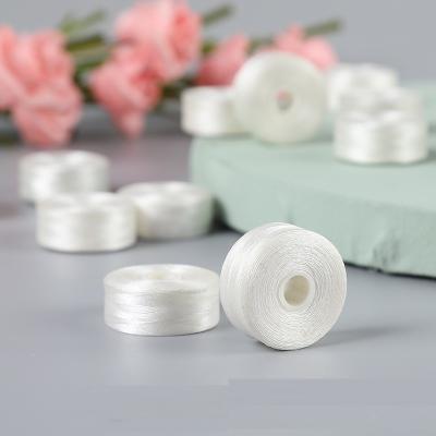 Cina 2 cm di diametro ricamo filo di fondo bianco senza confine L-tipo 75D/2 Shuttle Core cucitura prefondato bobbin 6 in vendita