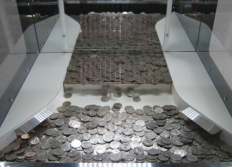 Side view showing coin mechanism of pusher machine