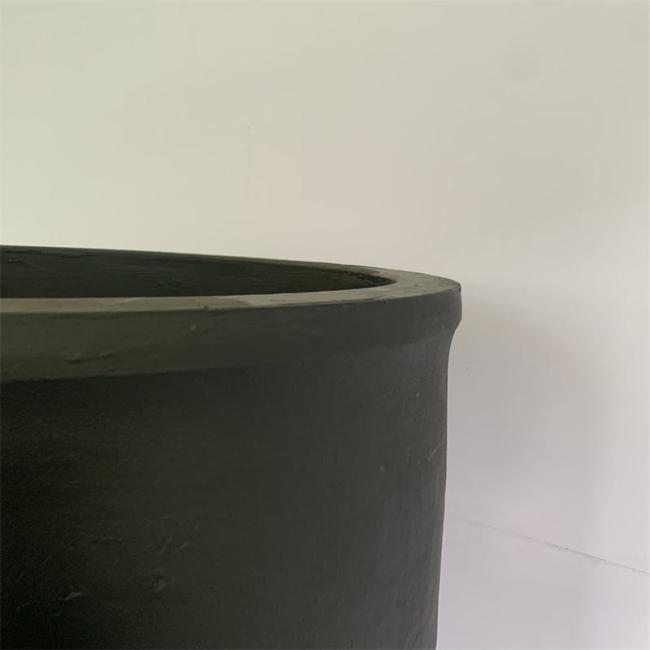 Graphite crucible in industrial setting with scale reference