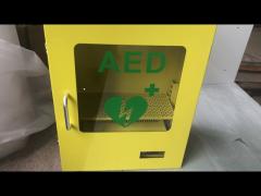 黄色い屋外の壁暖房装置が付いている台紙によって驚かされるAEDのキャビネット