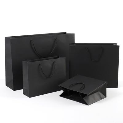 China Custom Logo Printed Cardboard Shopping Garment Black Retail Carry Luxury Packaging Gift Paper Bag With Ribbon Handle for sale