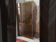 Elegante gabinete de chuveiro com vidro tintado e moldura de alumínio dourado