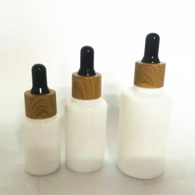 China Custom Glass Cosmetic Serum Bottle 30ml 1oz Frosted Round Shoulder Dropper Bottle For Essential Oils for sale