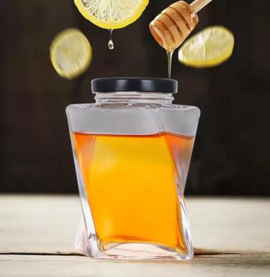 中国 360ml カスタム クリア トイスト 形 ミツバチ ガラス ボトル メタルキャップ付き ユニークな ミツバチボトル 販売のため