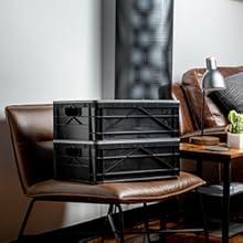 Two black SIDIO crates stacked on top of a leather chair