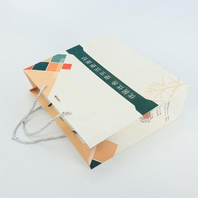 Cina L'acquisto del boutique copre Logo Paper Bag Printed White su ordinazione con la maniglia del nastro in vendita