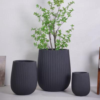 中国 ニュートラルベージュの丸い繊維粘土プランター、垂直ラインパターン、軽量で耐久性があり、メンテナンスが容易な植木鉢、ホリデーヴィラ、ホテル、ショッピングモール、オフィス装飾、庭の造園プロジェクト 販売のため