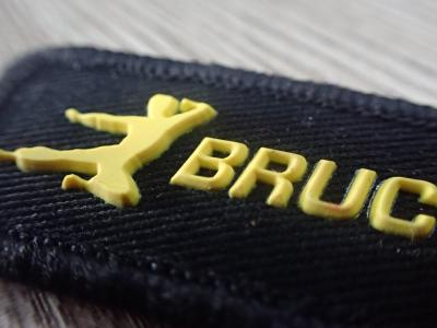 China Pantone Color Custom Clothing Patches 3D Silicon Injection Interlocking Edge Woven Label for sale