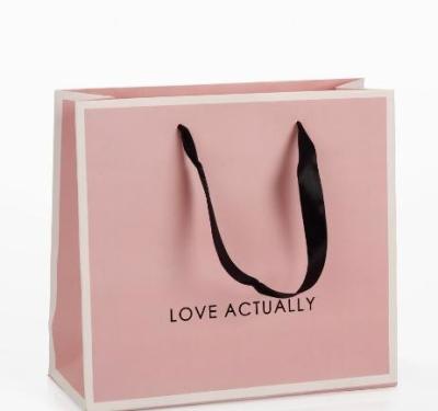 China Custom Design Pink Color Paper Clothes Shopping Bags With Handles And Logo for sale