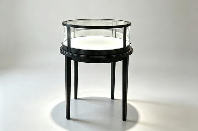 China Minimalist Round Jewelry Display Table with Tempered Glass Showcase and Matte Black Metal Stand Featuring Built-in LED Lighting for sale
