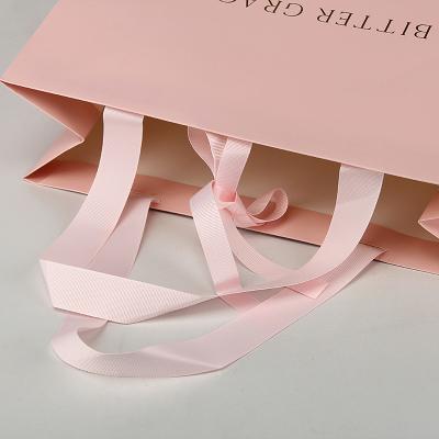 中国 200gsmペーパー顧客用買い物袋はリボンのハンドルのロゴのペーパー小売り袋を飾る 販売のため