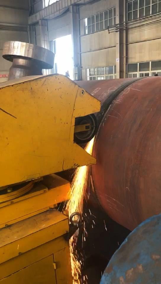 Close-up view of welded seam polishing machine working on tank surface