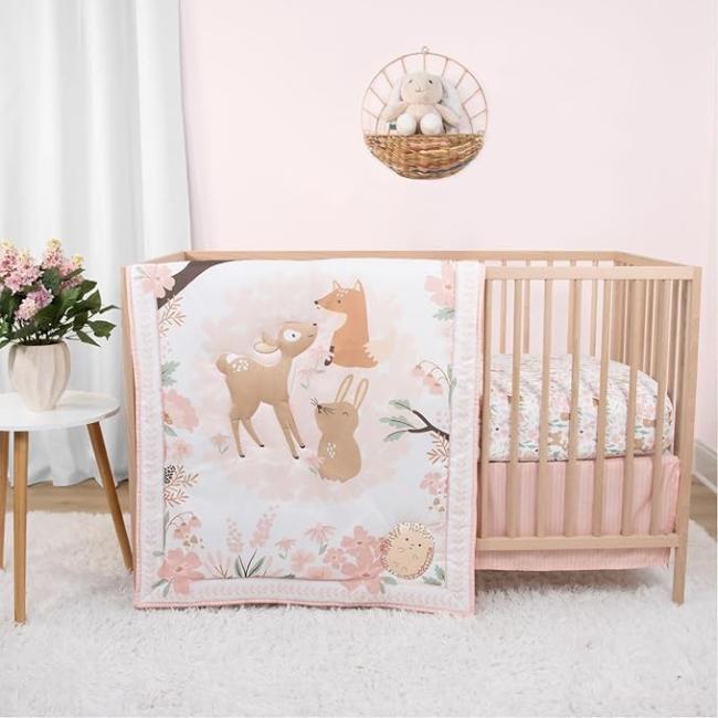Forest themed baby crib bedding set showing quilt, sheet, and plush toy
