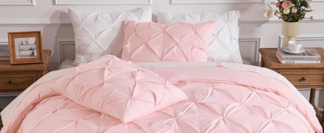 Pink pinch pleat comforter set displayed on a bed