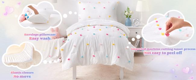 Toddler bed fully made with white pom-pom bedding set