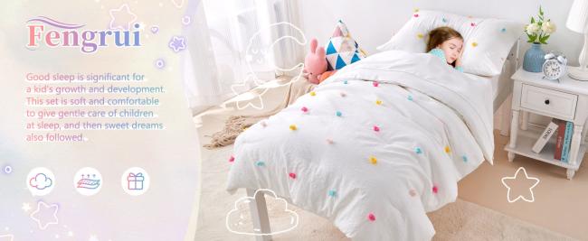 White pom-pom jacquard toddler bedding set displayed on a crib