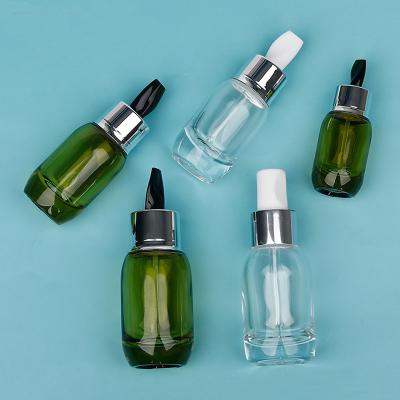China Skin Care Serum Cream Bottles 15ml 30ml 50ml Clear Green Glass Designs with Stirring Stick Customizable for sale