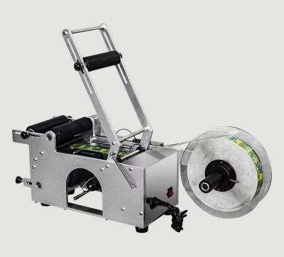 China Small Manual Round Bottle Labeling Machine Desktop Adhesive Labeler for Plastic Glass Bottles for sale