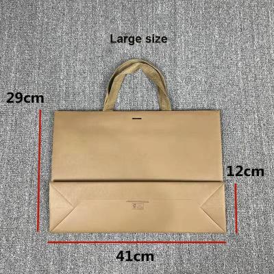 Cina 200pcs al nastro dei sacchi di carta dell'abbigliamento di timbratura di oro 500pcs tratta i sacchetti della spesa di Kraft in vendita