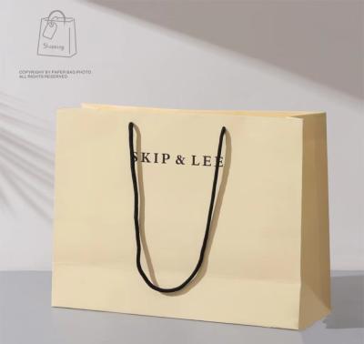 Cina Sacchetto della spesa di carta al minuto di timbratura caldo di Matte Black Paper Bag Gold della maniglia del Grosgrain in vendita