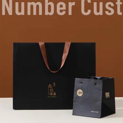 Cina Sacchetto della spesa di carta al minuto di timbratura caldo di Matte Black Paper Bag Gold della maniglia del Grosgrain in vendita