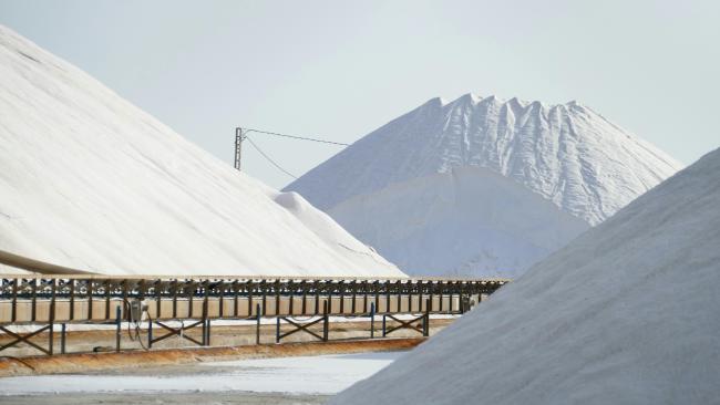 Industrial salt conveyor and storage showing upstream flow of sodium chloride before packaging