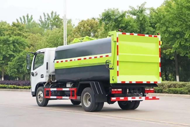 Self-loading garbage truck in operation